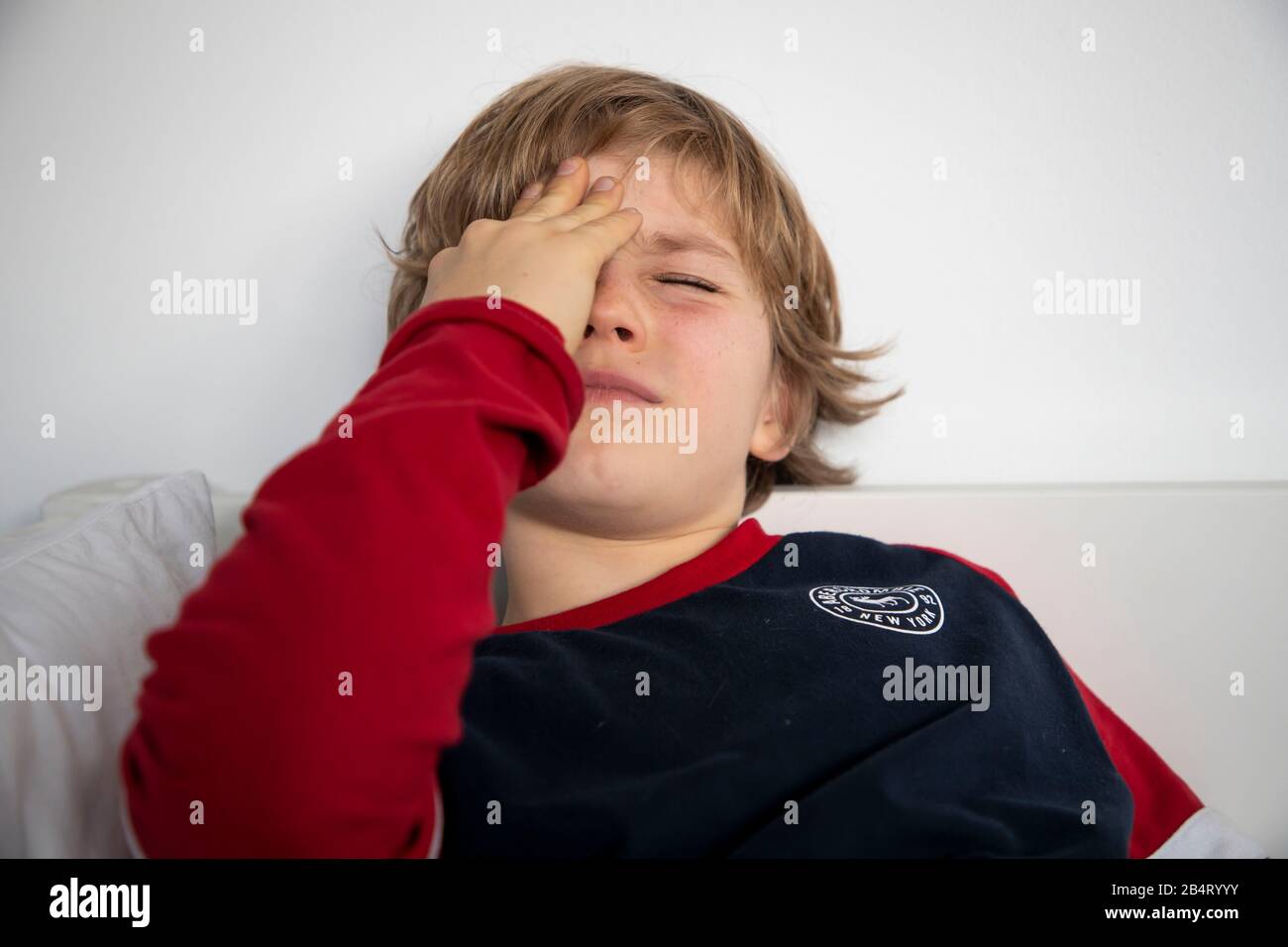 Child with headache, boy 9 years old, with pain distorted face ...