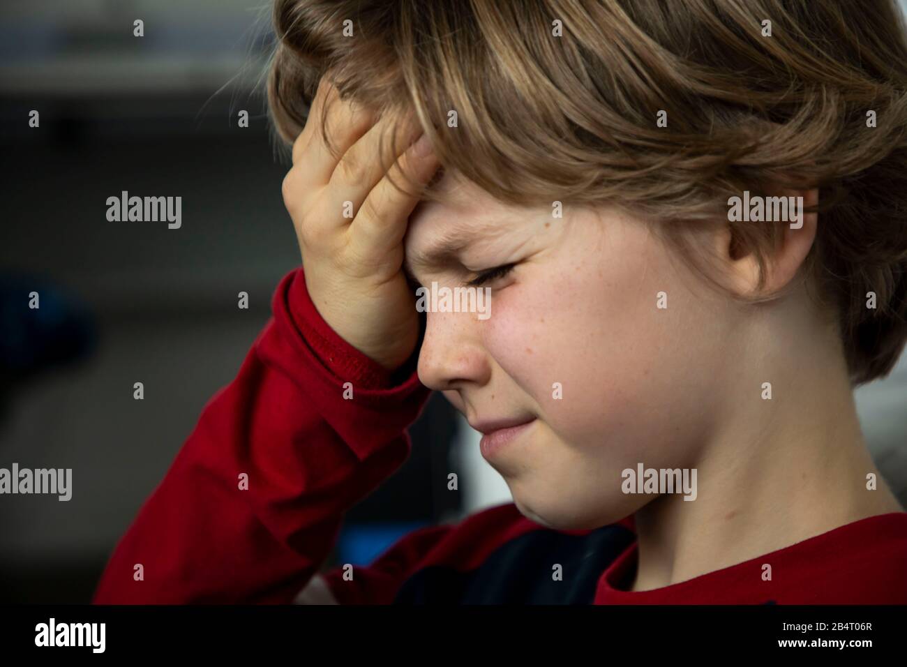 Child with headache, boy 9 years old, with pain distorted face ...