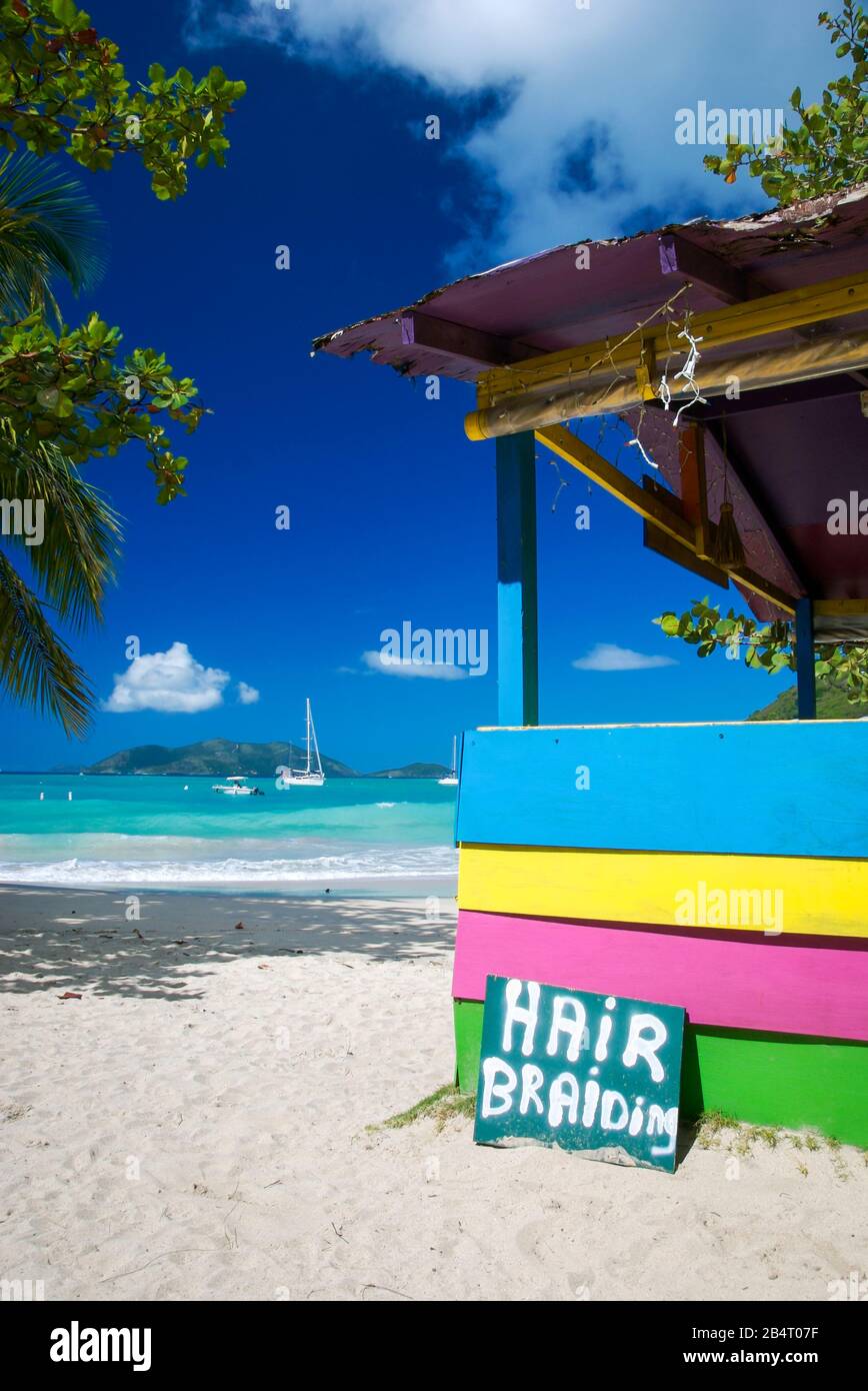 Rustic handwritten sign for hair braiding leaning in the sand against a ...