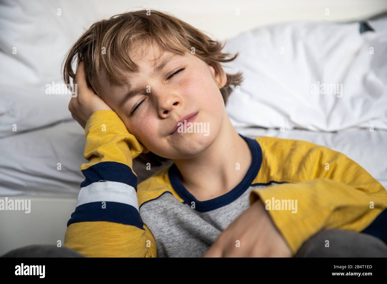 Child with headache, boy 9 years old, with pain distorted face ...