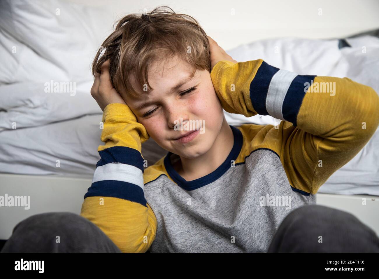 Child with headache, boy 9 years old, with pain distorted face ...