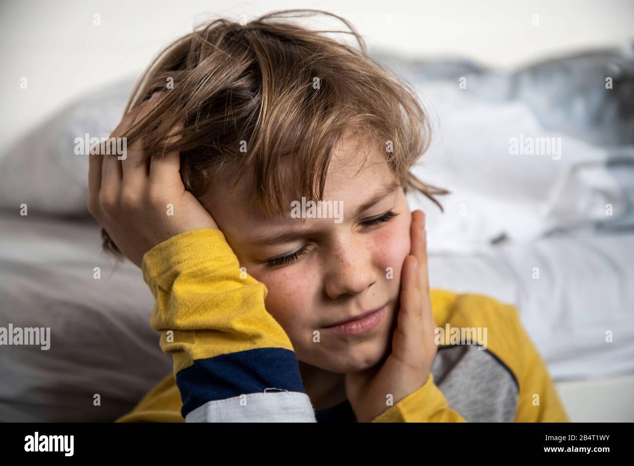 Child with headache, boy 9 years old, with pain distorted face ...
