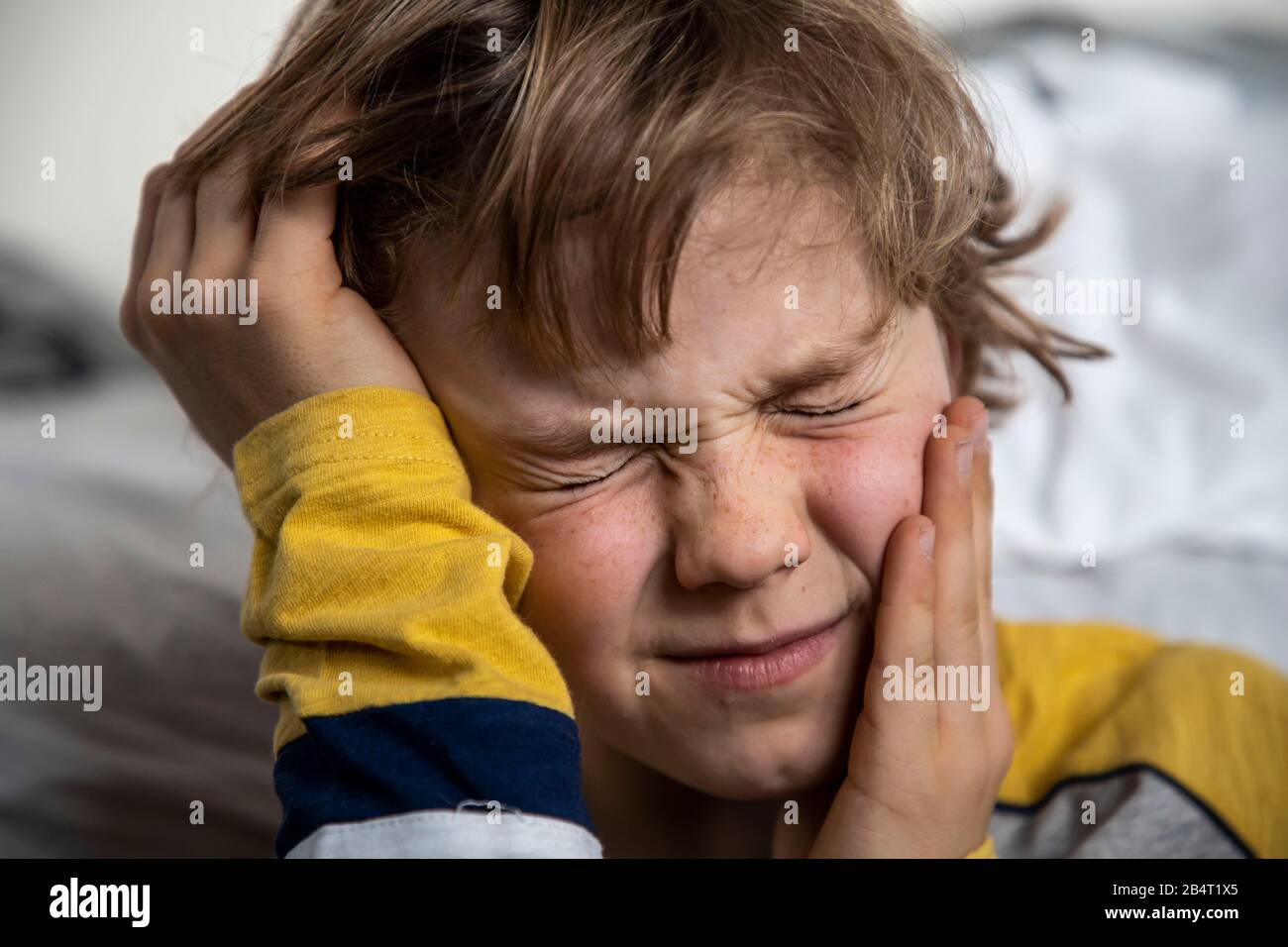Child with headache, boy 9 years old, with pain distorted face ...
