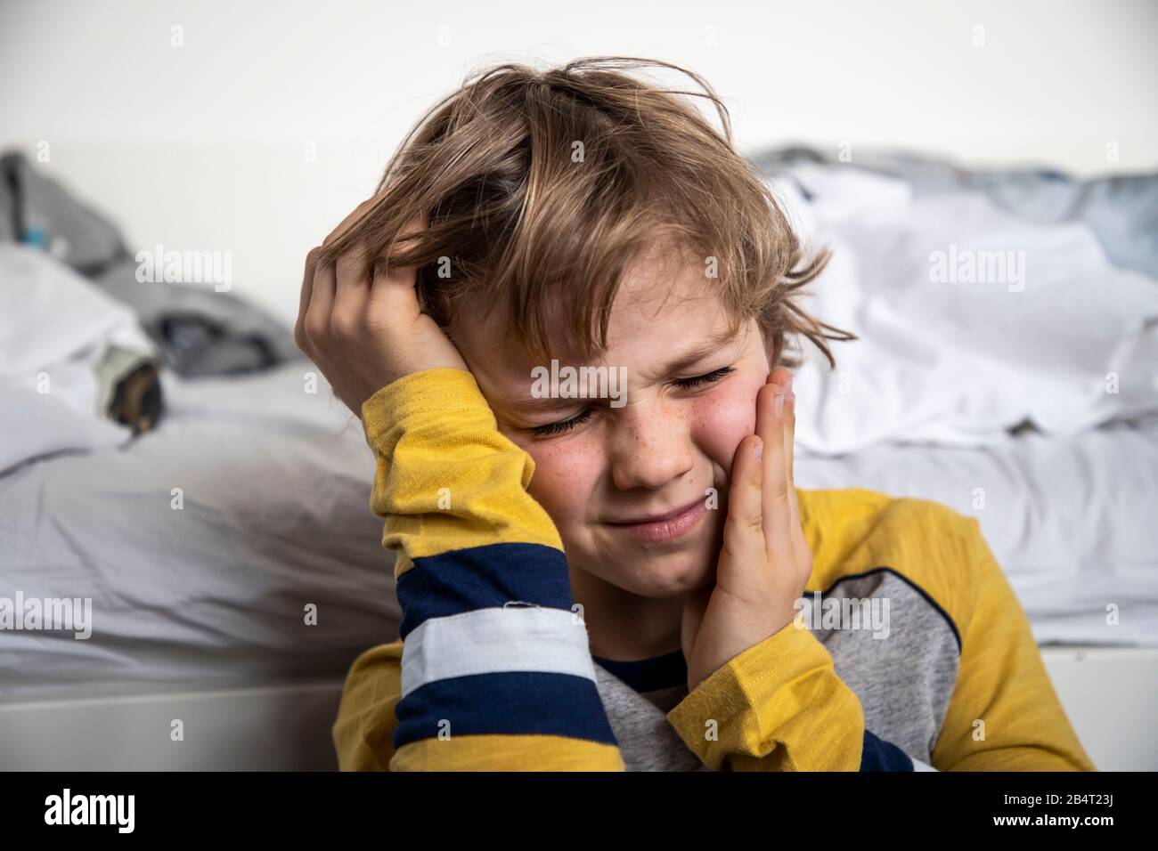 Child with headache, boy 9 years old, with pain distorted face ...