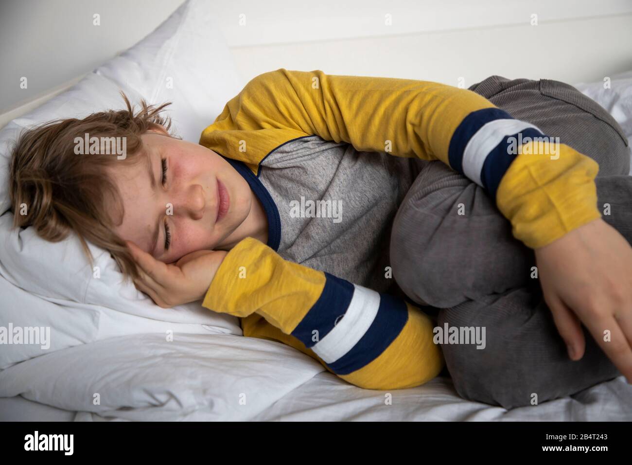 Child with headache, boy 9 years old, with pain distorted face ...
