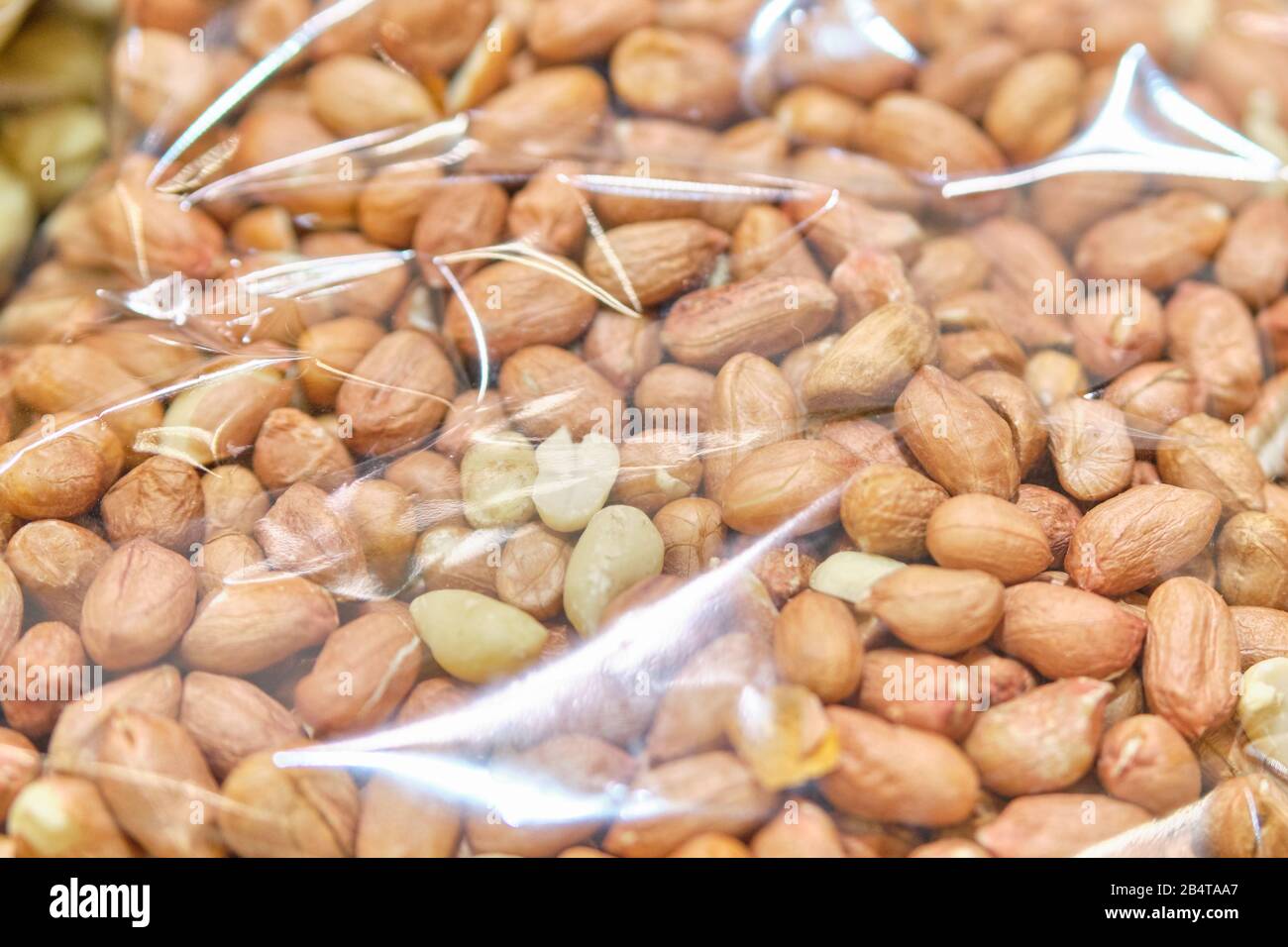 Packing from a transparent bag with Brazil nuts. Close up Stock Photo ...