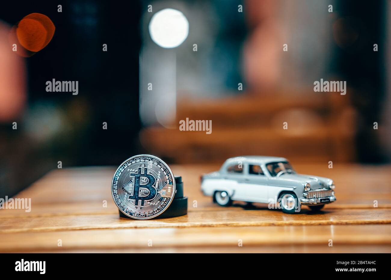 Silver bitcoin and Moskvich 401 on the table, glowing background Stock ...
