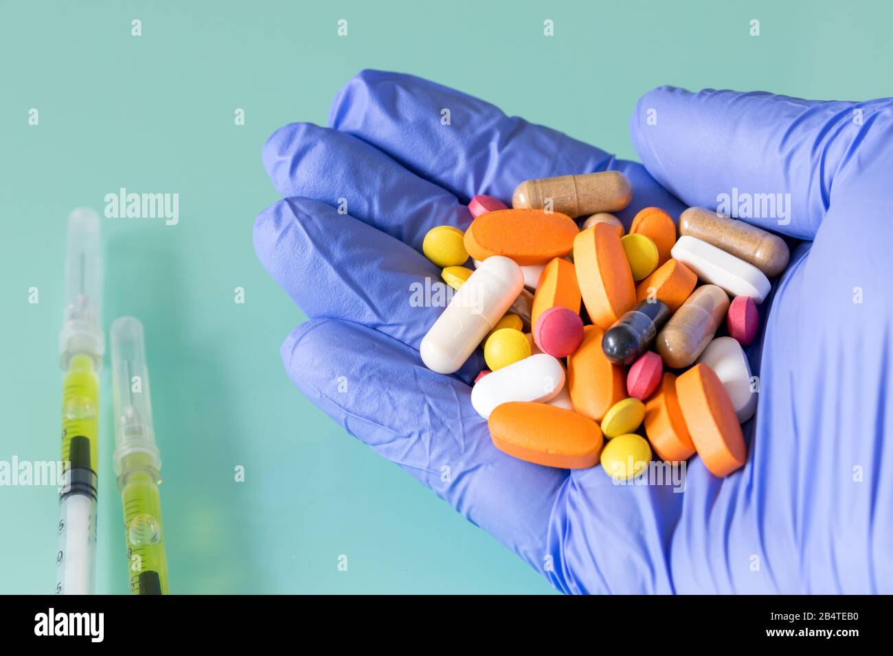A handful of different colored drugs in the hand of a doctor. The ...