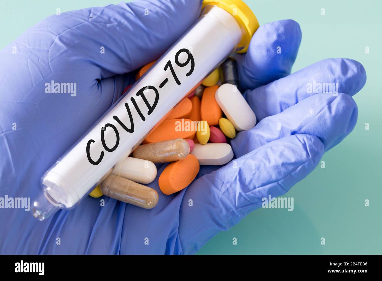 a vial of Covid-19 virus with a handful of medication in your hand in a ...