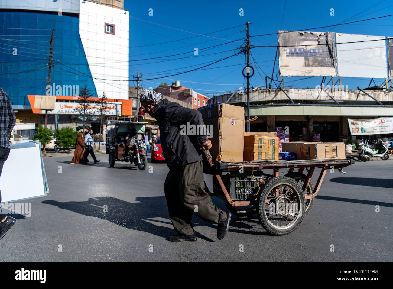 Kurdish man pulling a fully loaded cart across the raod Stock Photo - Alamy