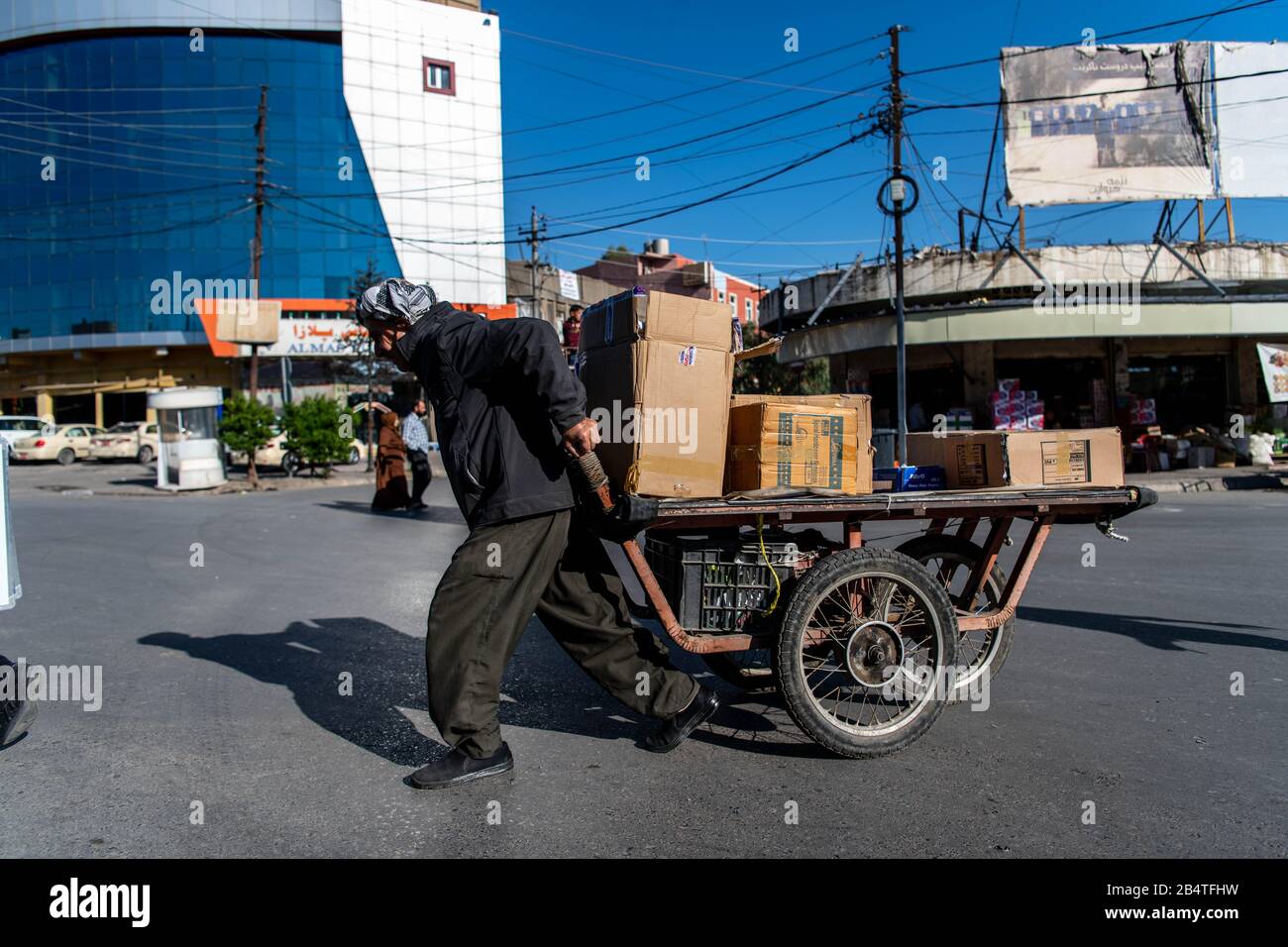 Kurdish man pulling a fully loaded cart across the raod Stock Photo - Alamy