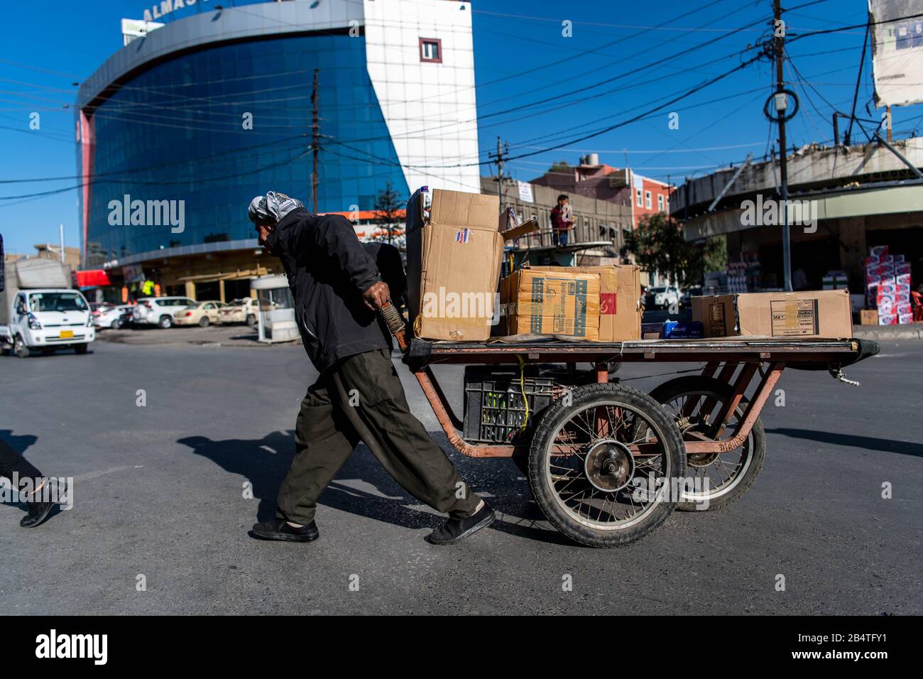 Kurdish man pulling a fully loaded cart across the raod Stock Photo - Alamy