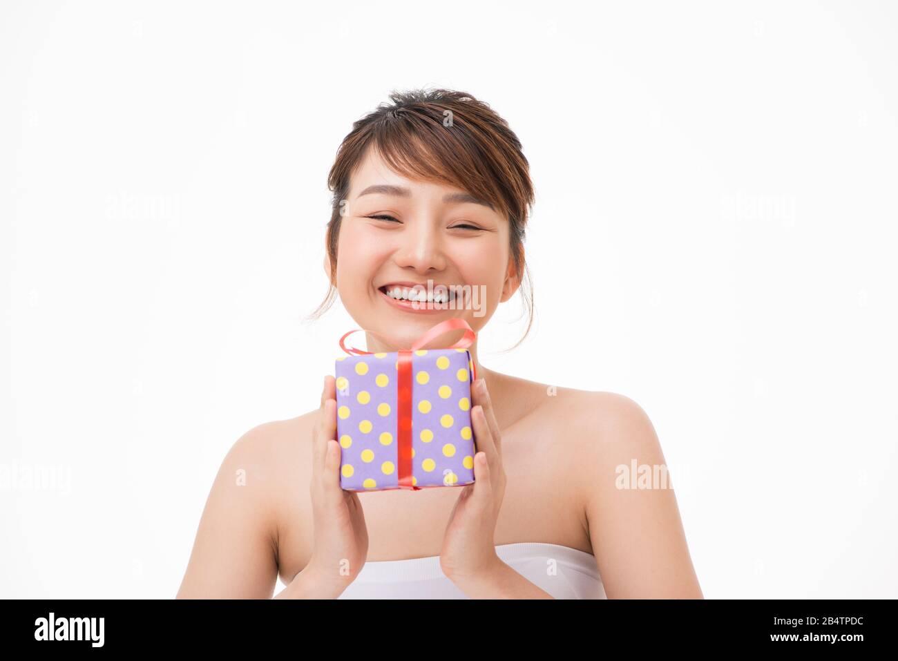 A portrait of beautiful girl holding a gift box isolated on white ...