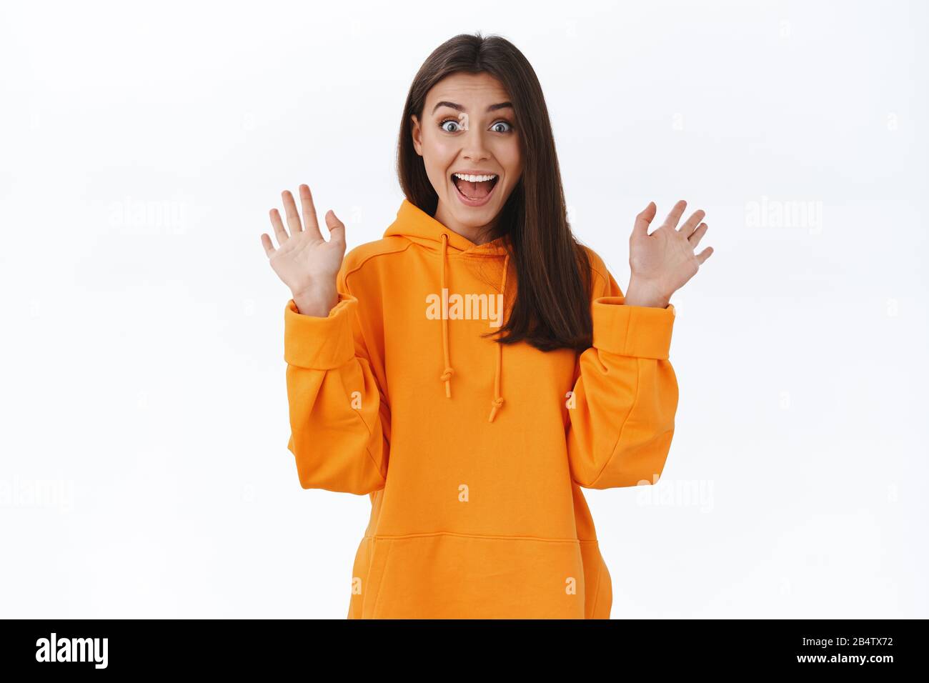 Adorable happy and surprised brunette girl seeing her friend unexpected ...