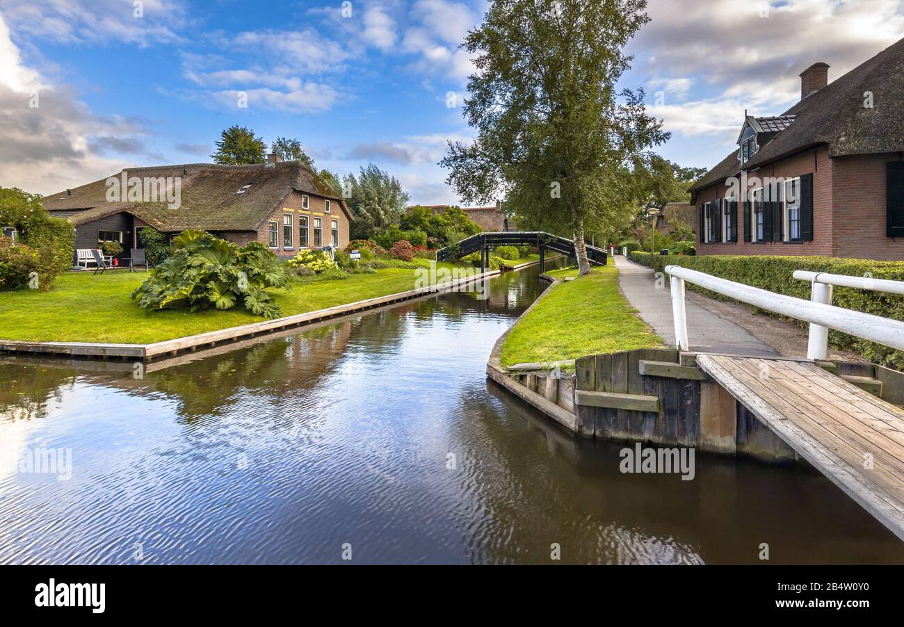 Landscape view of famous Giethoorn village with canals and rustic thatched roof houses in farm ...