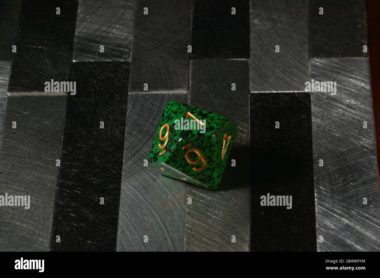 Green ten-sided polyhedral die on a gray tile table Stock Photo - Alamy