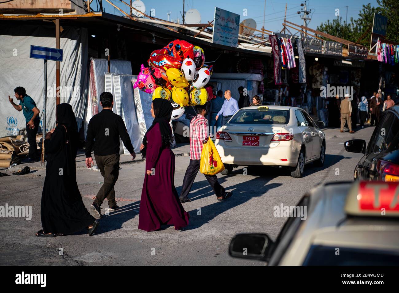 Iraq, Iraqi Kurdistan, Arbil, Erbil. A man is walking with baloons in ...