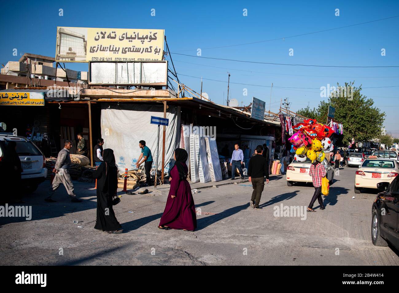 Iraq, Iraqi Kurdistan, Arbil, Erbil. A man is walking with baloons in ...