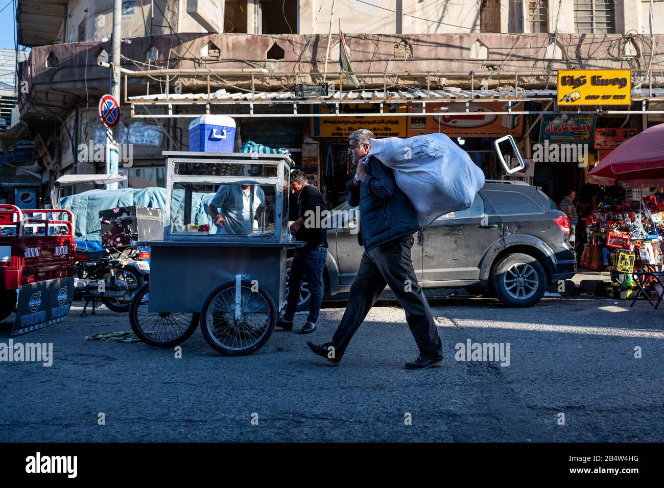 Iraq, Iraqi Kurdistan, Arbil, Erbil. In the foreground, a man is ...