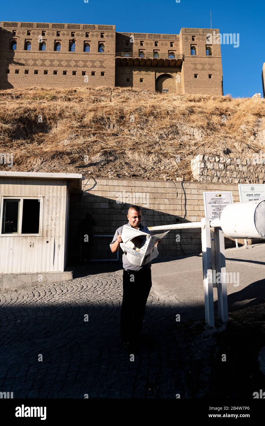 Iraq, Iraqi Kurdistan, Arbil, Erbil. A man is reading a newspaper at ...
