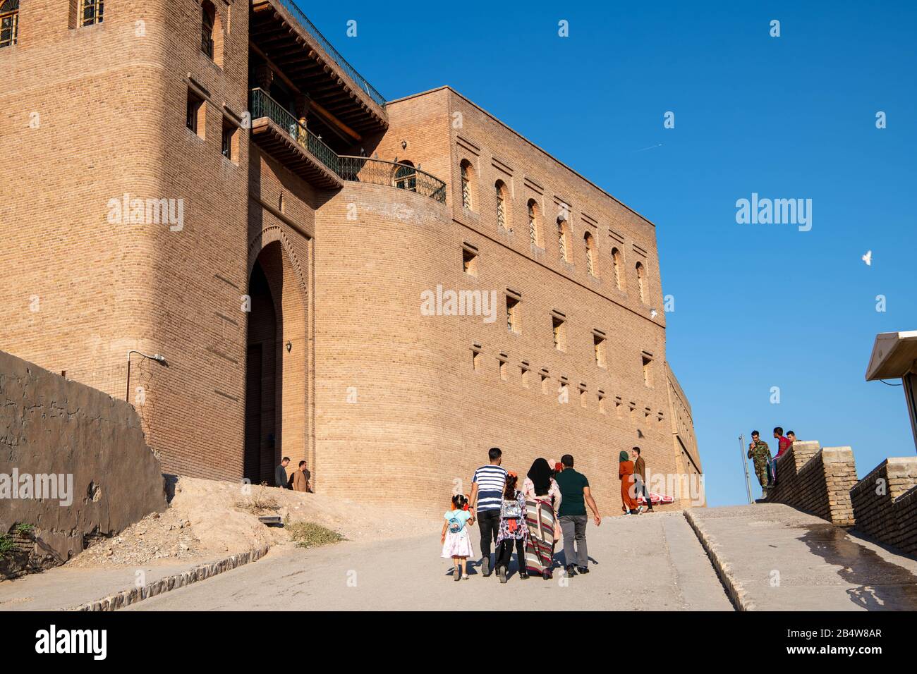 Iraq, Iraqi Kurdistan, Arbil, Erbil. A family is walking up the road to ...