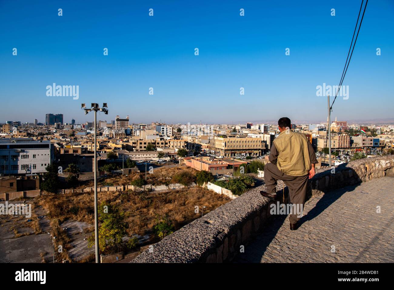 Iraq, Iraqi Kurdistan, Arbil, Erbil. A man is looking over the edge at ...