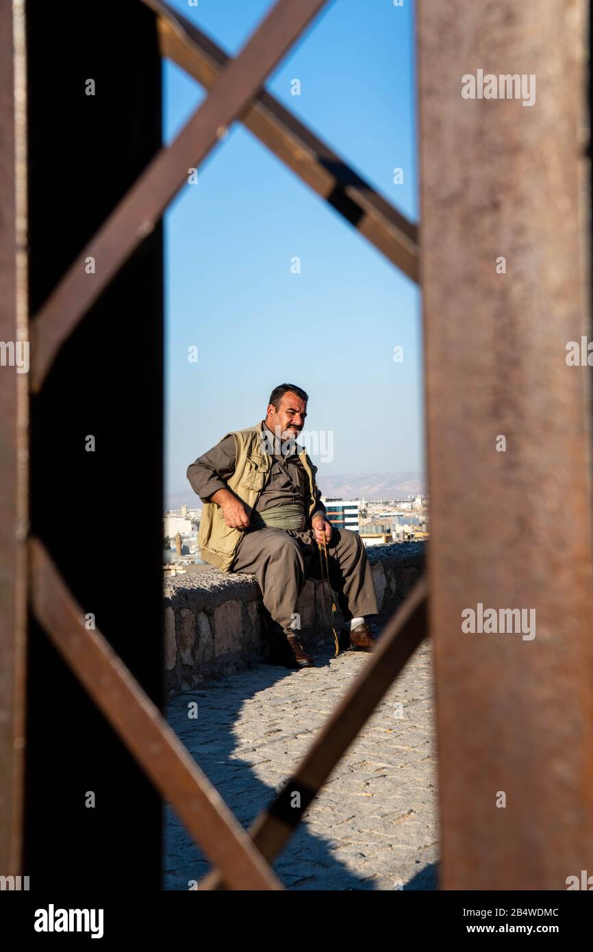 Iraq, Iraqi Kurdistan, Arbil, Erbil. man sitting on the edge of the ...