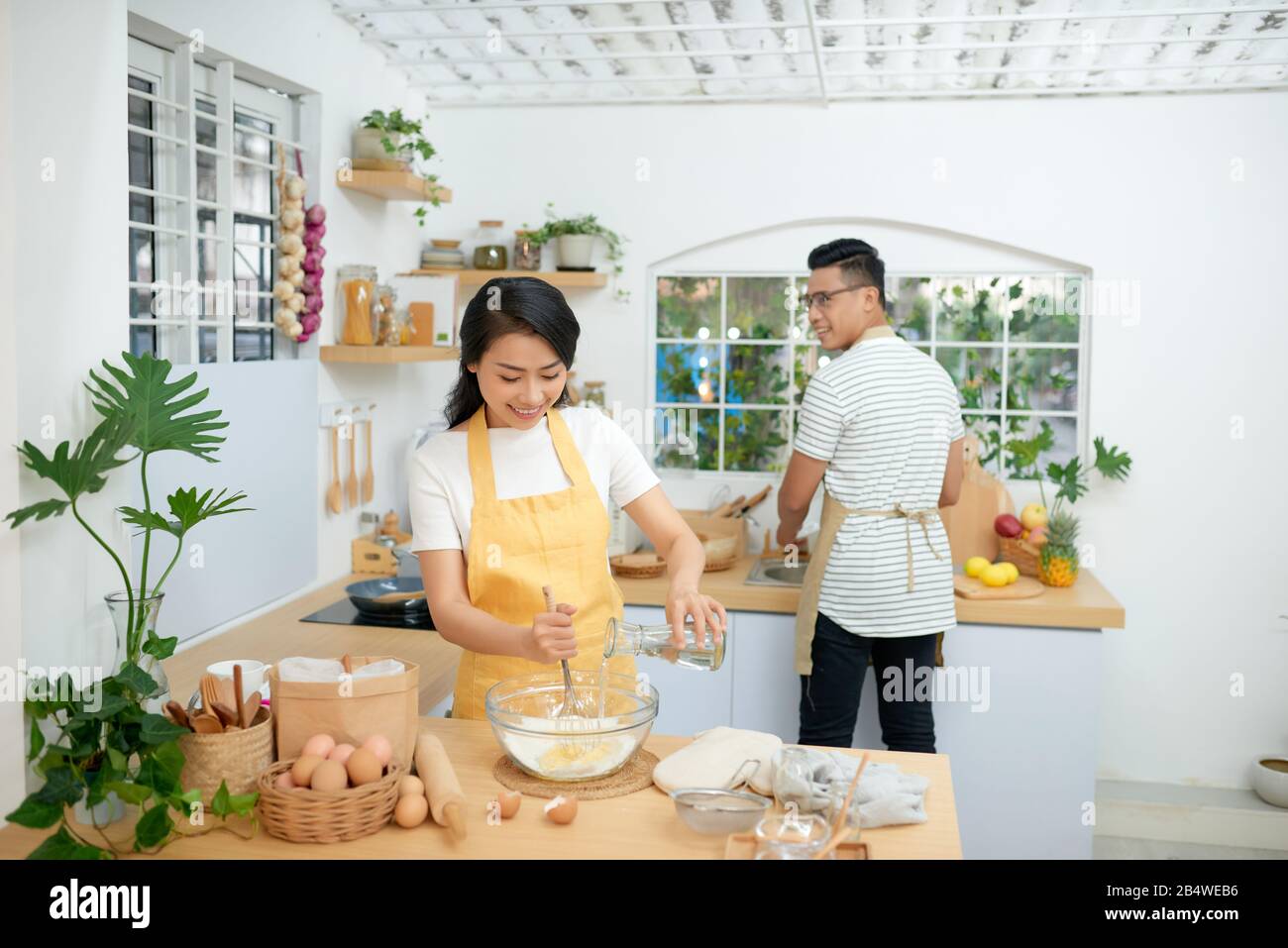 Couple cooking bakery in kitchen room, Young asian man and woman ...