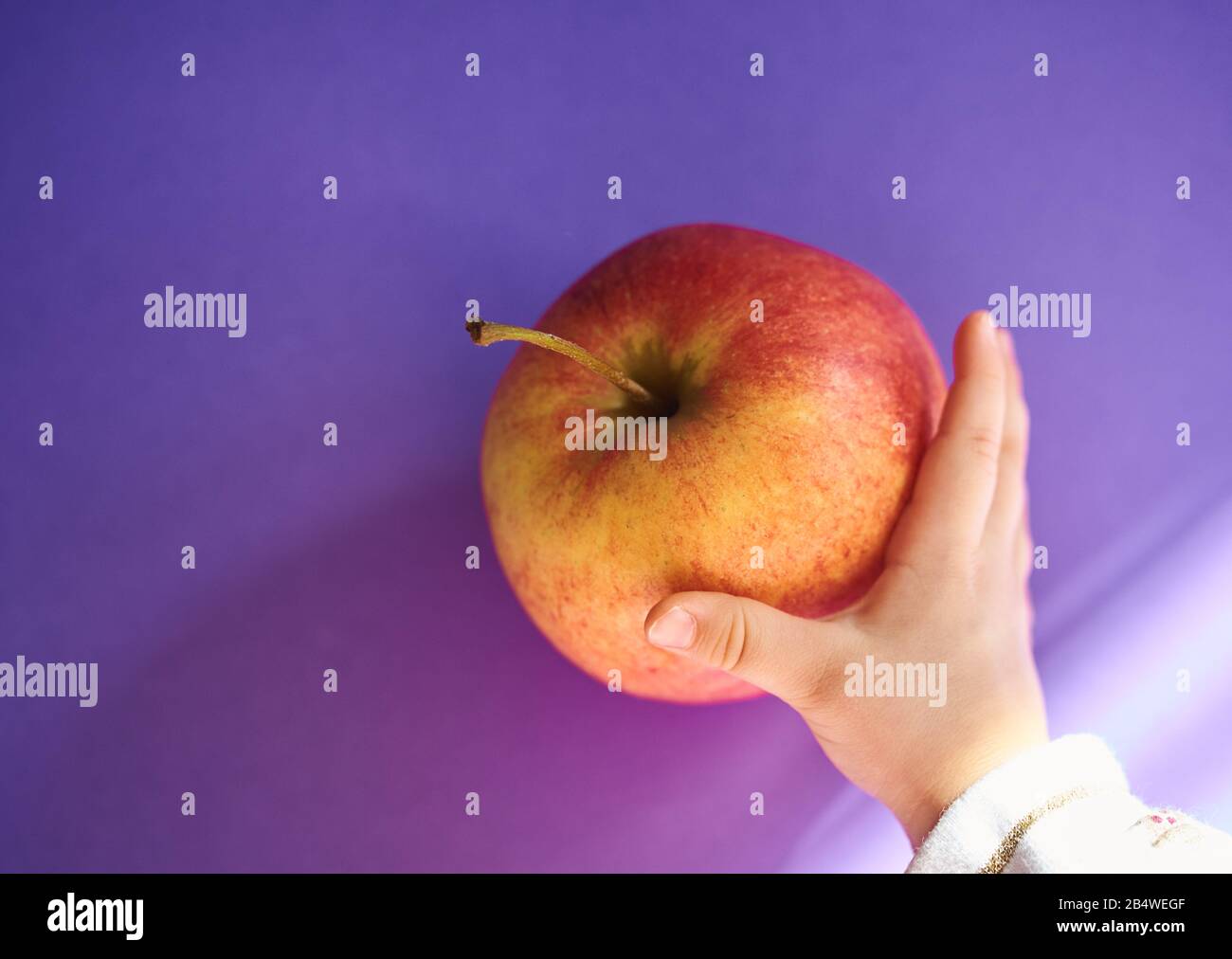 Hand of a baby grabbing an apple from a table Stock Photo - Alamy