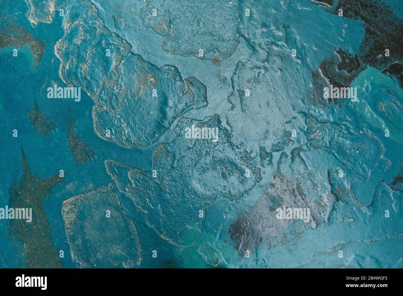 Stone wall painted in turquoise color with gray stains Stock Photo - Alamy