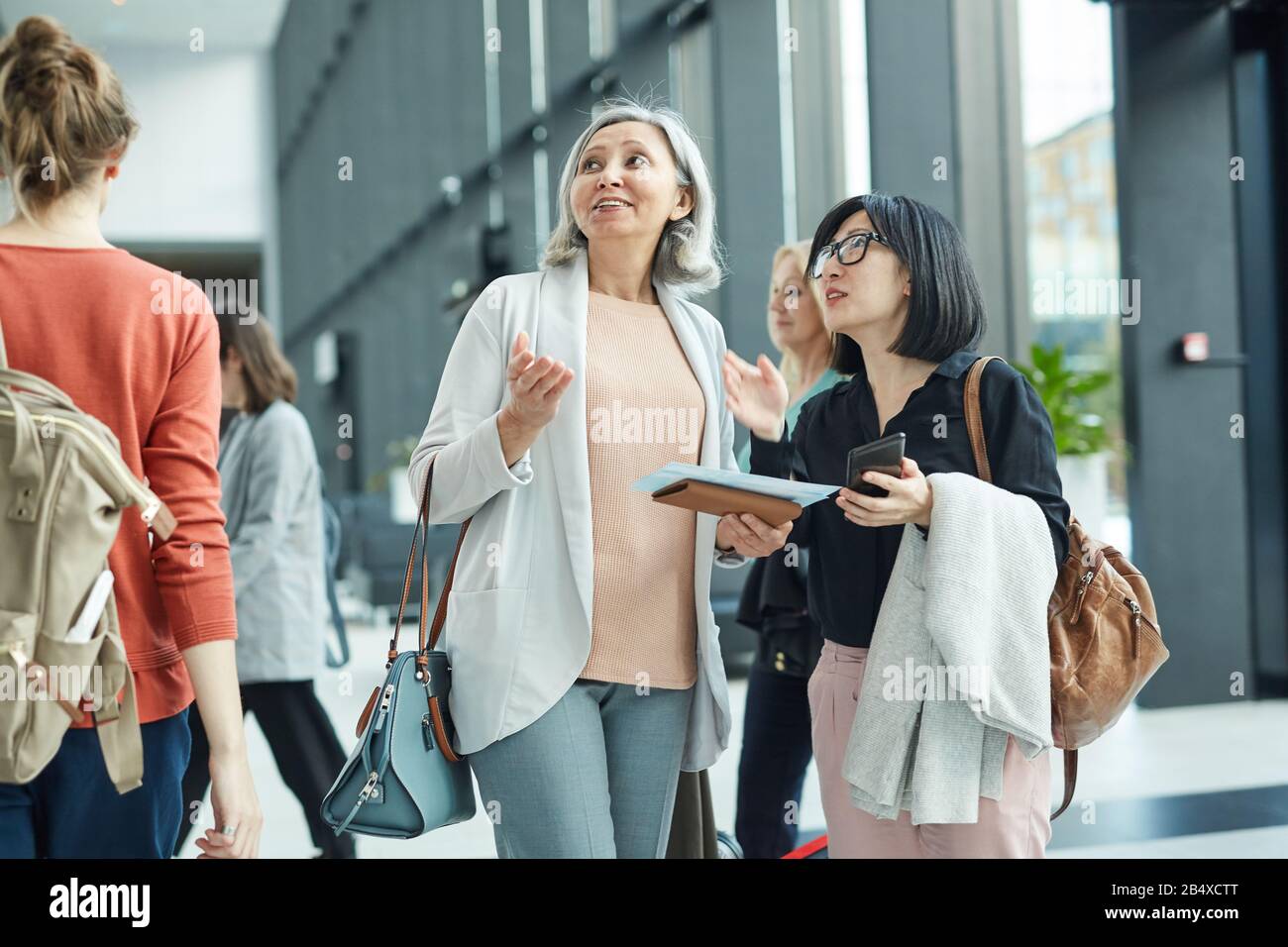 Two women standing next to each other hi-res stock photography and ...