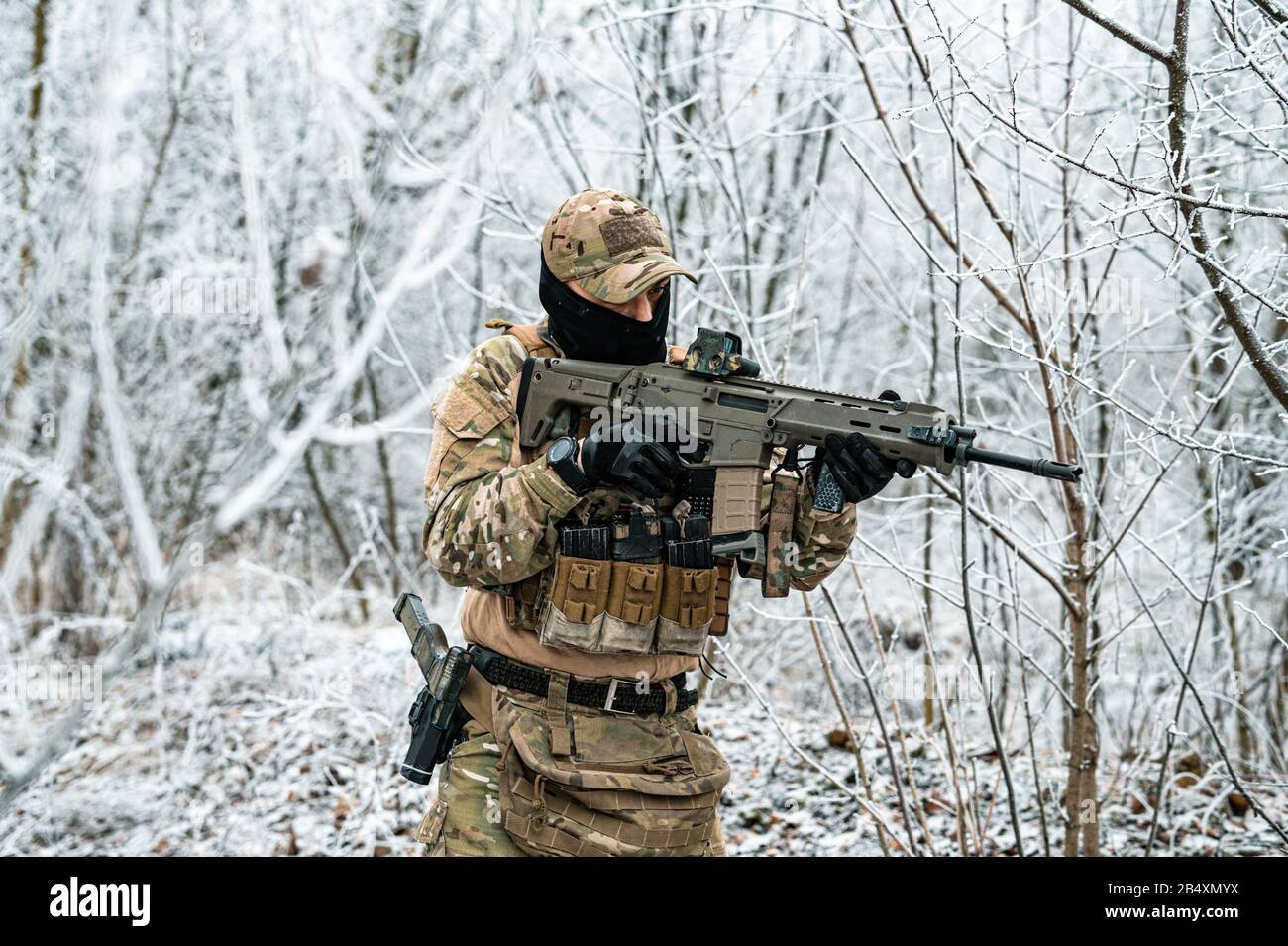 Airsoft man in camouflage uniform and machinegun with optical sight ...