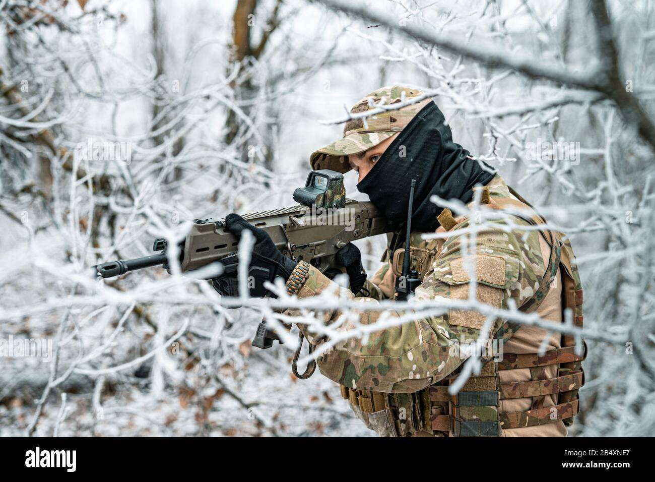 Airsoft man in camouflage uniform and machinegun with optical sight ...