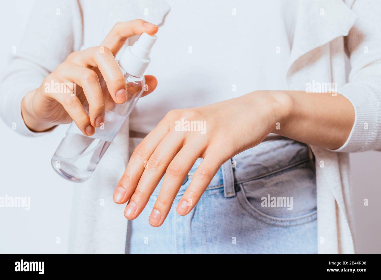 Female hands applying antibacterial disinfectant spray to skin, close ...