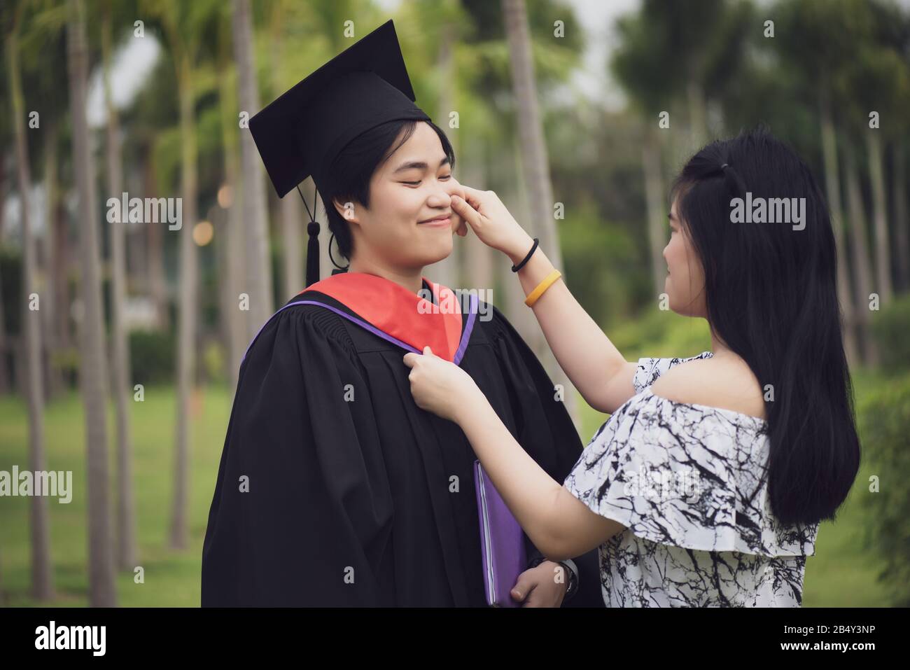 Graduation ceremony. Young female graduate hugging each other with her ...
