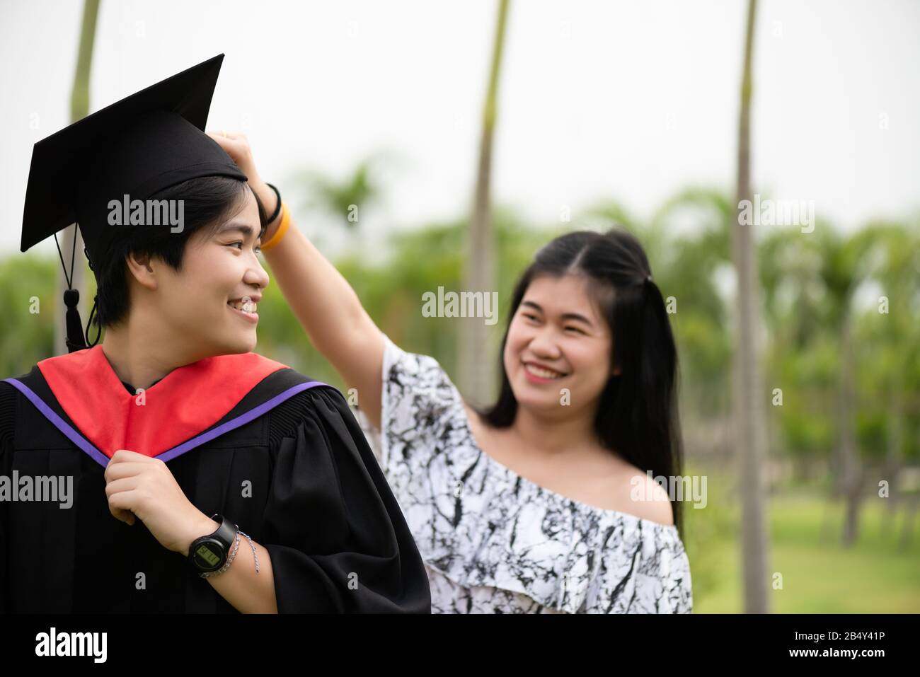 Graduation ceremony. Young female graduate with her friend congratulate ...