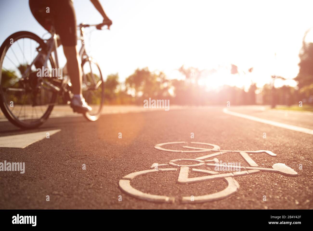 Close up cycling logo image on road with athletic women cyclist legs ...