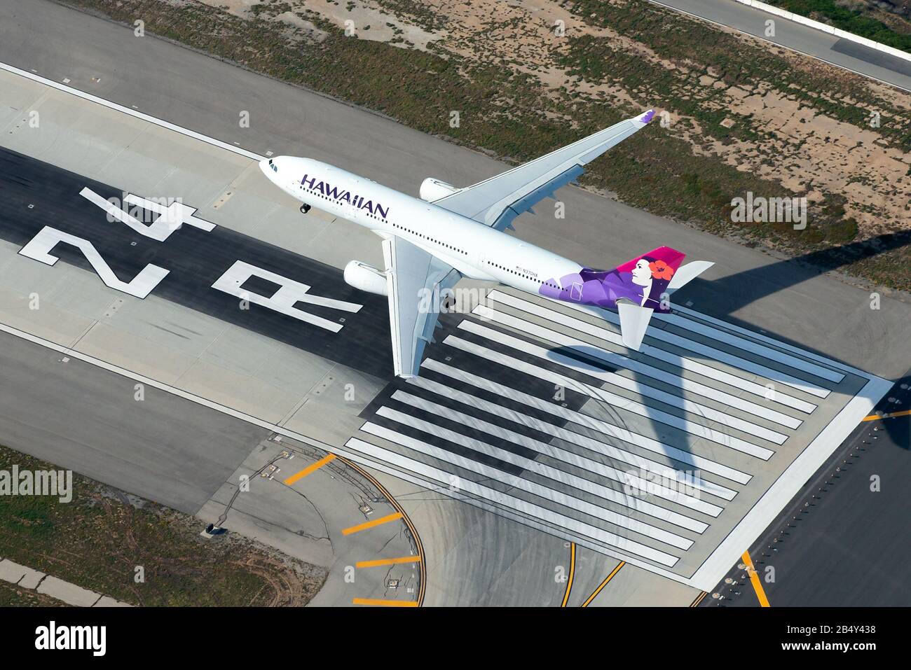 Aerial view of Hawaiian Airlines Airbus A330 over runway 24R marks ...