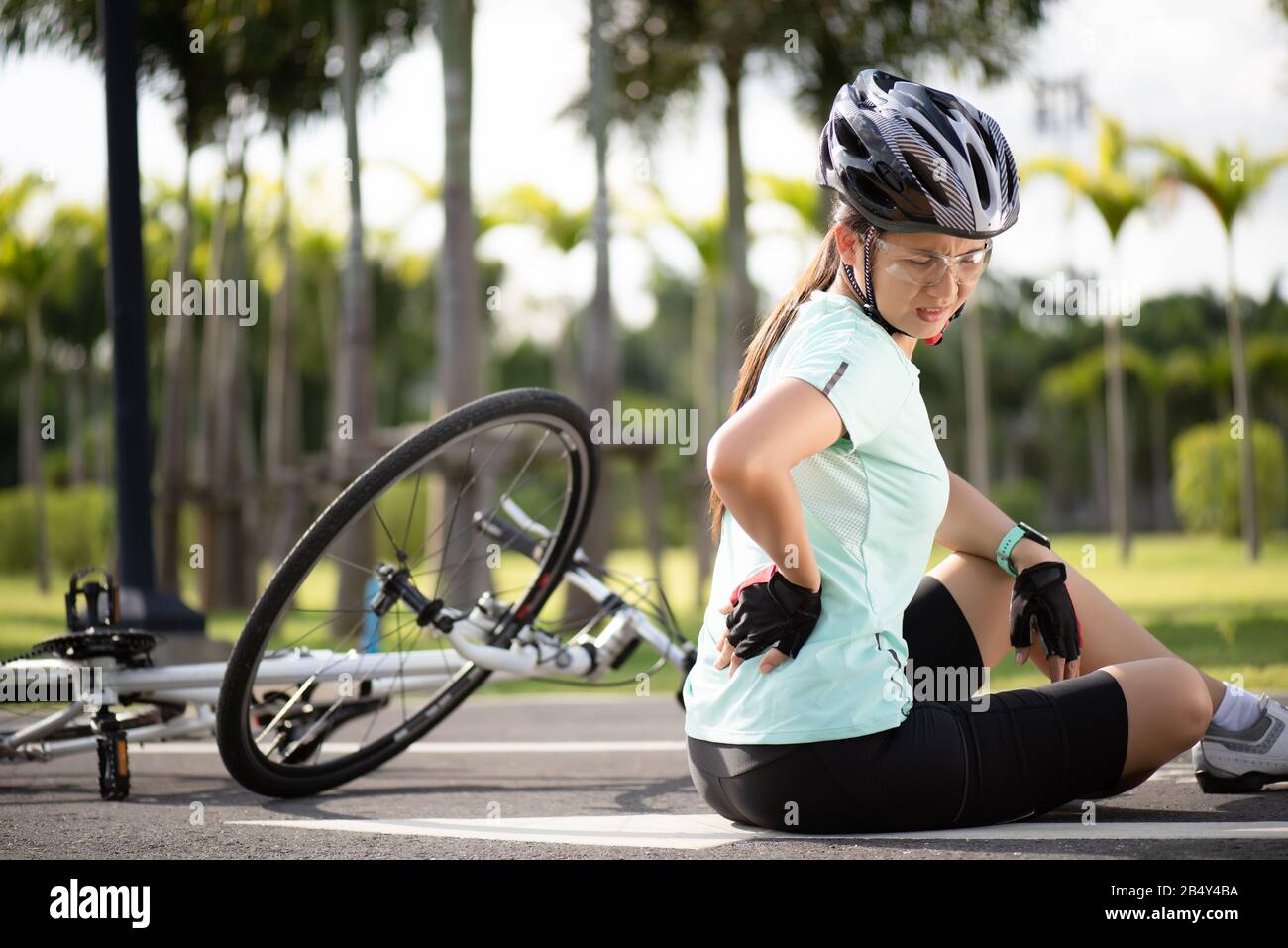 Bike injuries. Woman cyclist fell off road bike while cycling. Bicycle ...