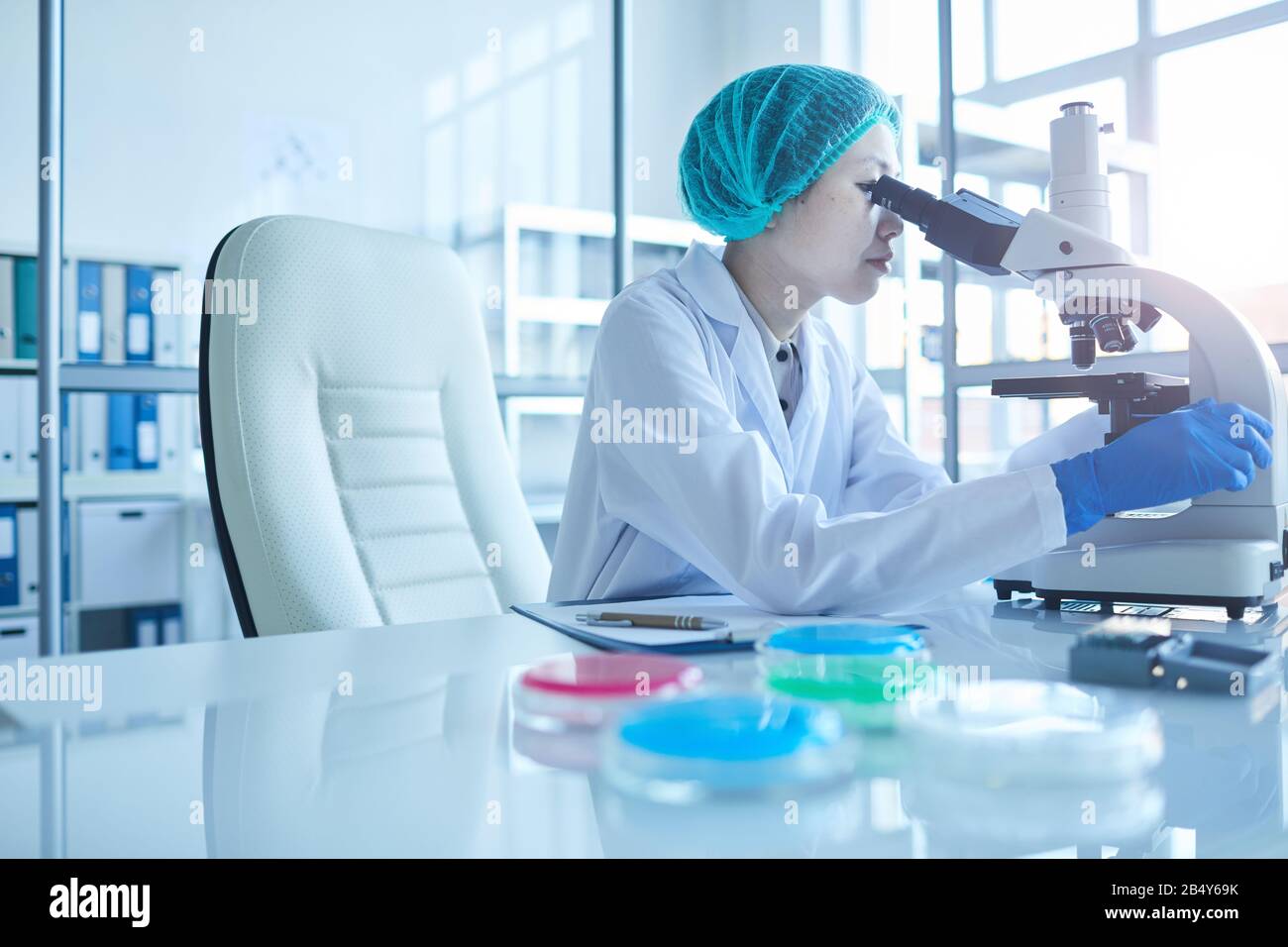 Horizontal shot of female Asian medical scientist working in modern ...