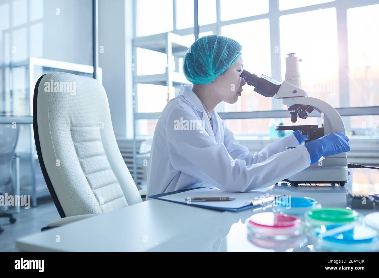 Horizontal medium side view portrait of young Asian female scientist ...