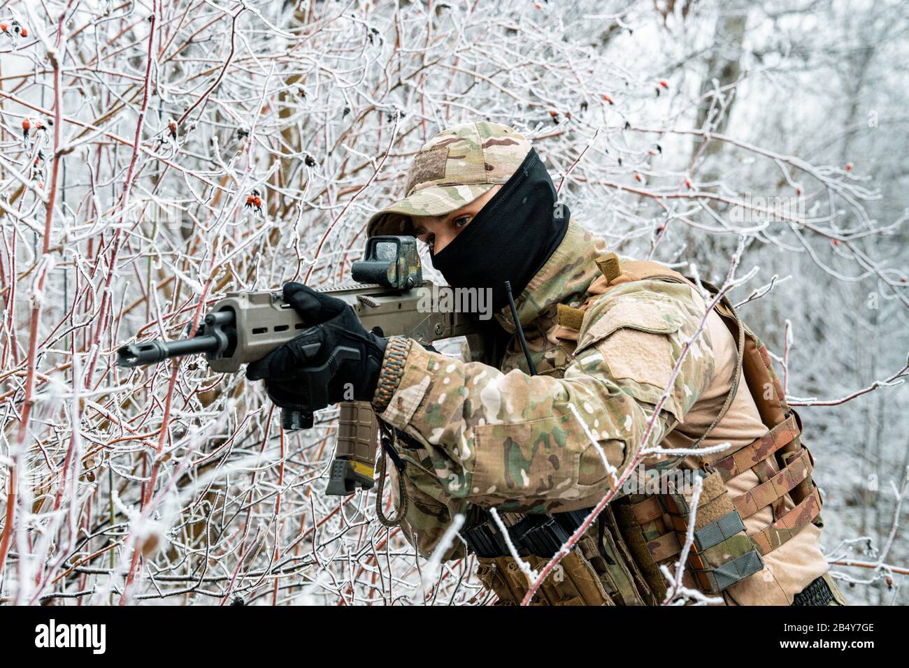 Airsoft man in camouflage uniform and machinegun with optical sight ...