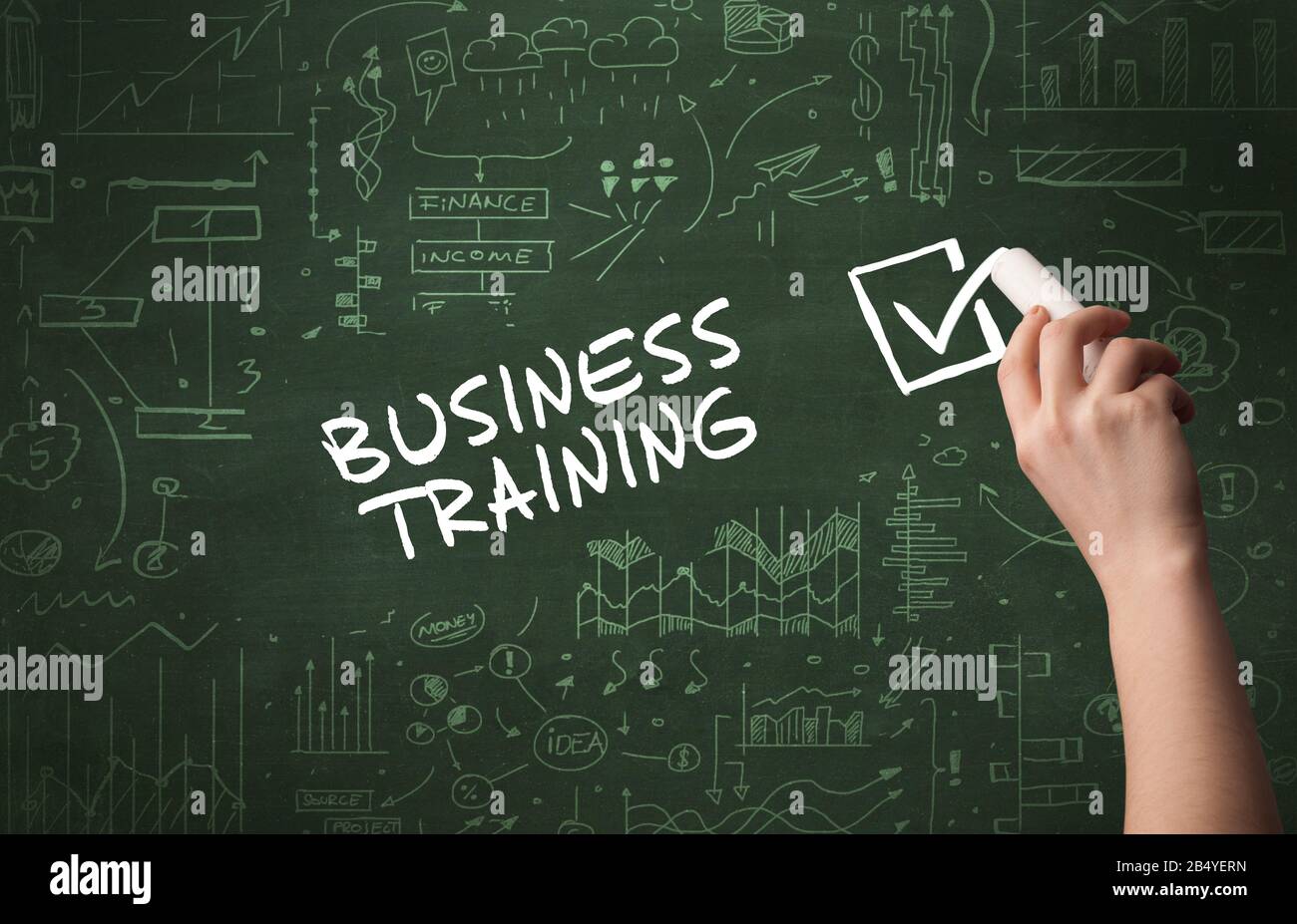 Hand drawing BUSINESS TRAINING inscription with white chalk on ...