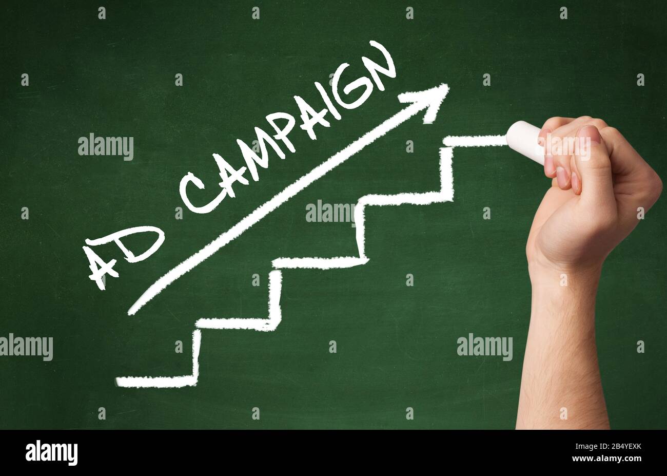 Hand drawing AD CAMPAIGN inscription with white chalk on blackboard ...