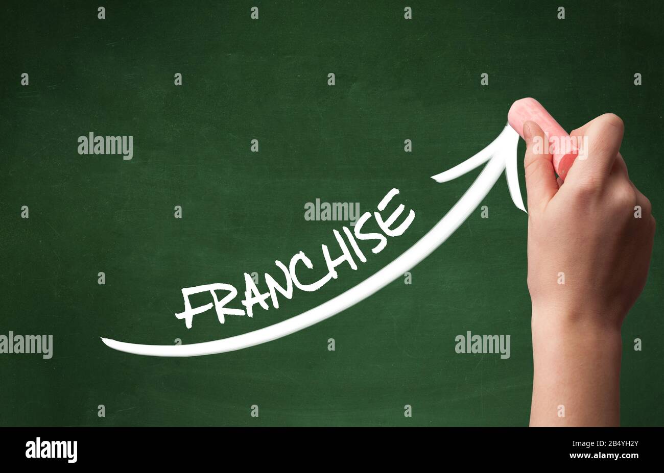 Hand drawing FRANCHISE inscription with white chalk on blackboard ...