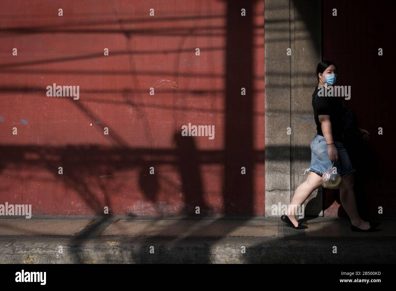 A woman wears a face mask as a precaution against the outbreak of ...