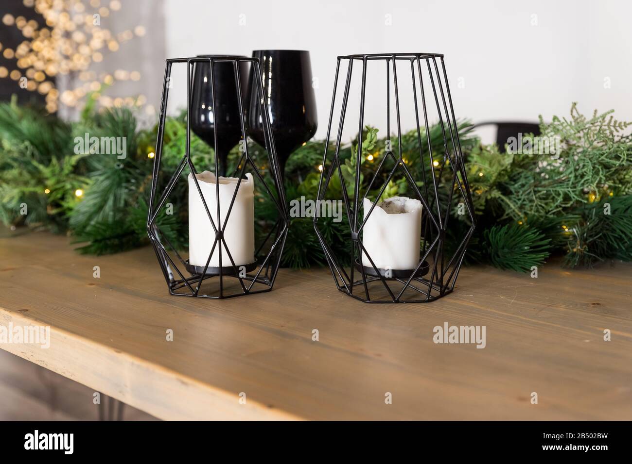 Lit Candle in Metal Candle Holder on wooden table with light bokeh ...