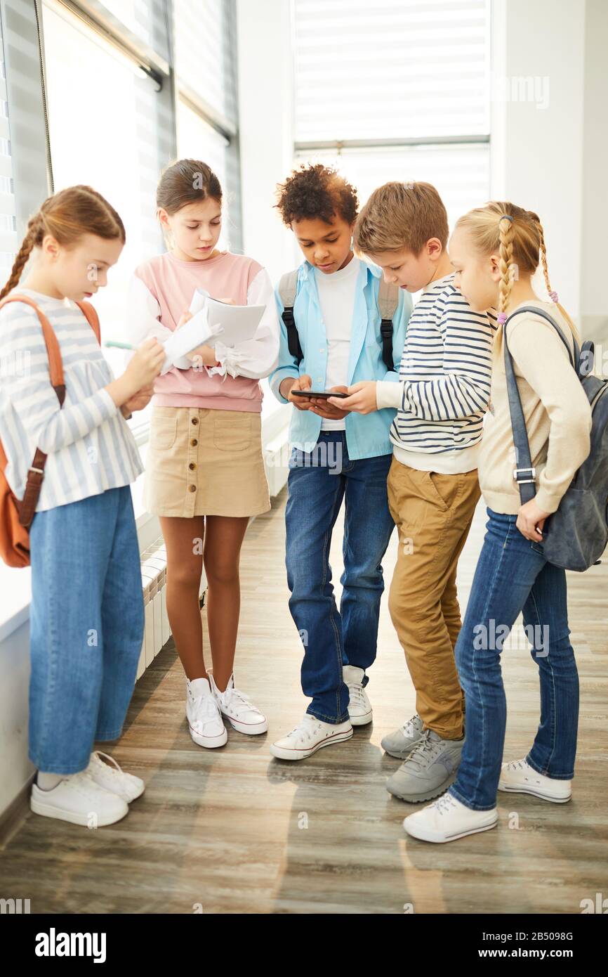 Group of five classmates standing together in school corridor ...