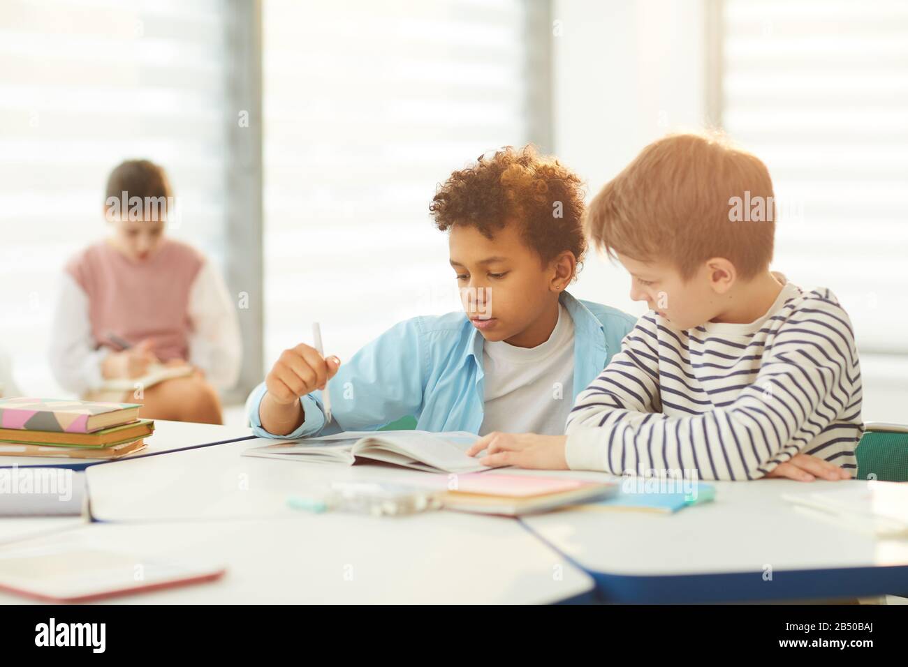 Horizontal portrait of two middle school male students sitting at desk ...