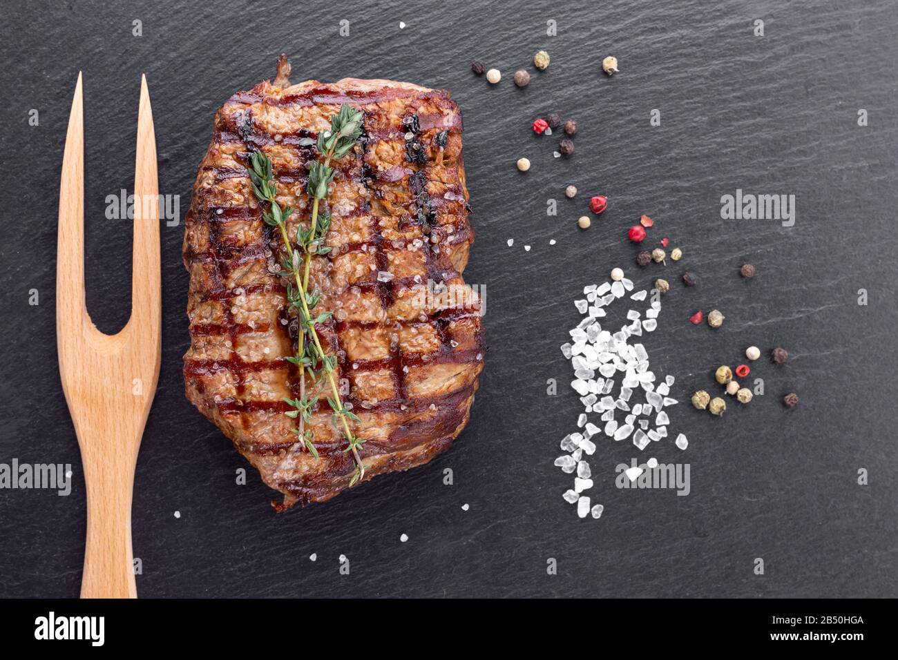 Beef steak with spices on a black slate board Stock Photo - Alamy